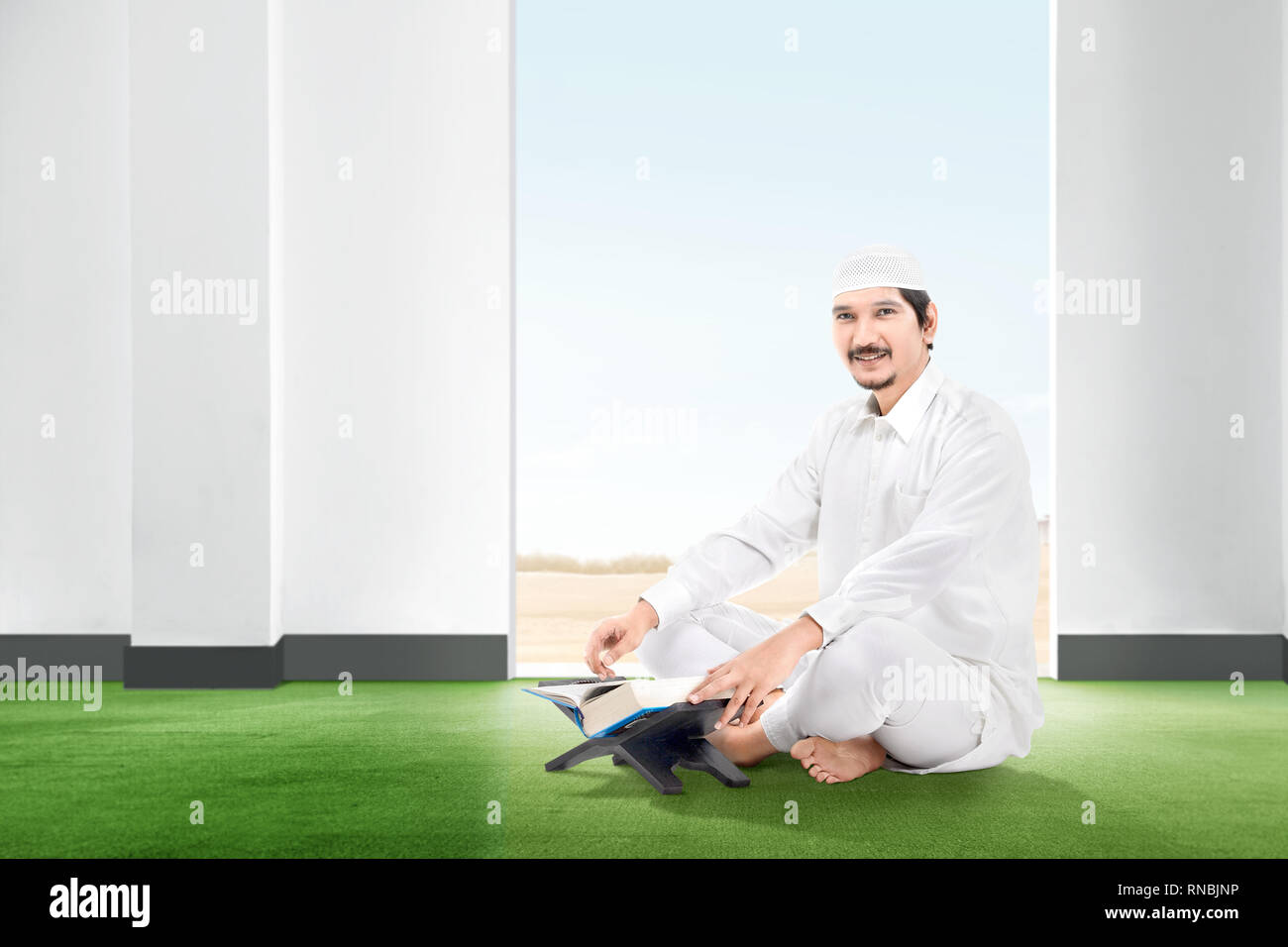 Smiling asian muslim man sitting on the carpet with koran inside the ...