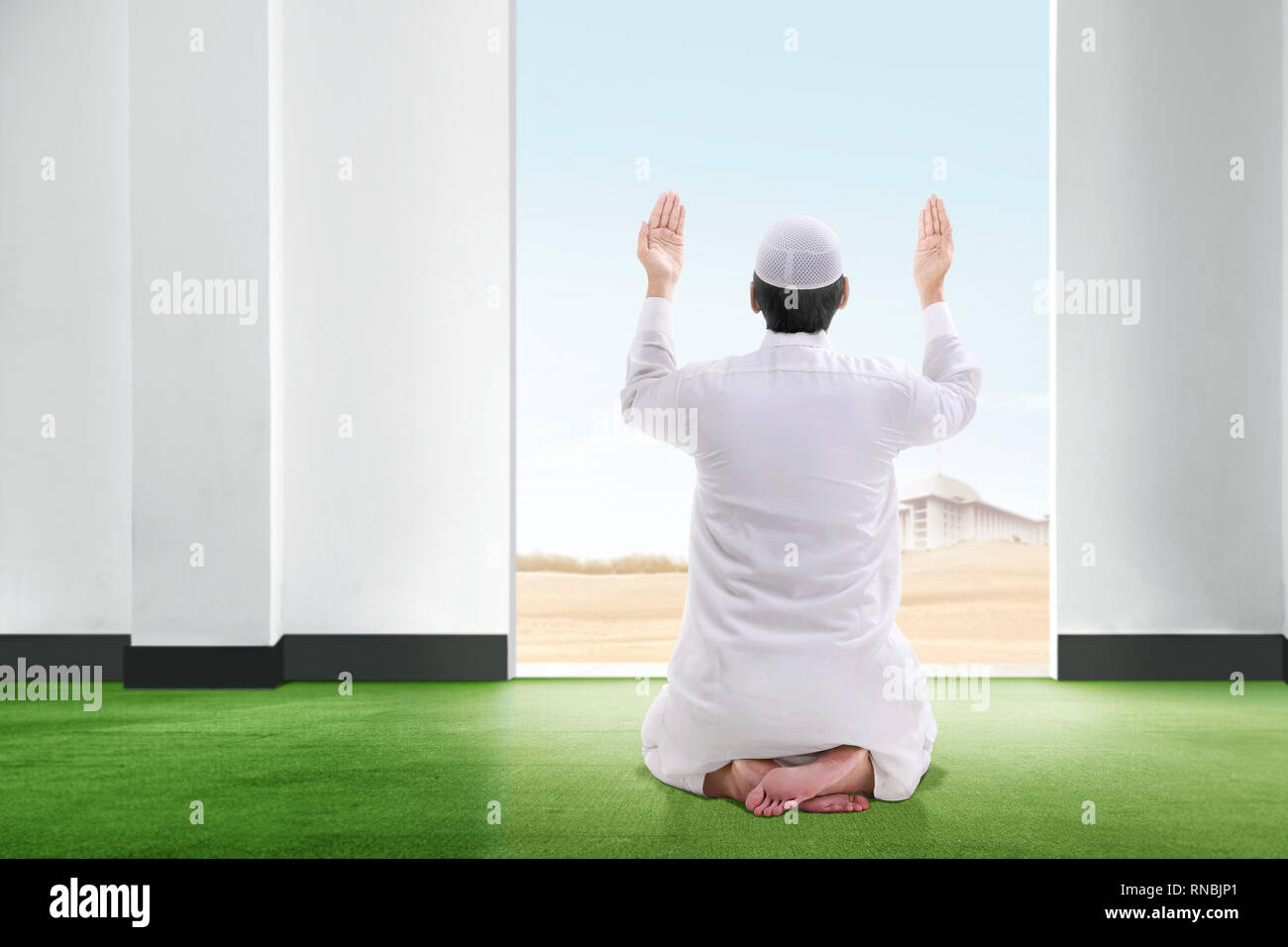 Back view of asian muslim man sitting in praying position on the carpet ...