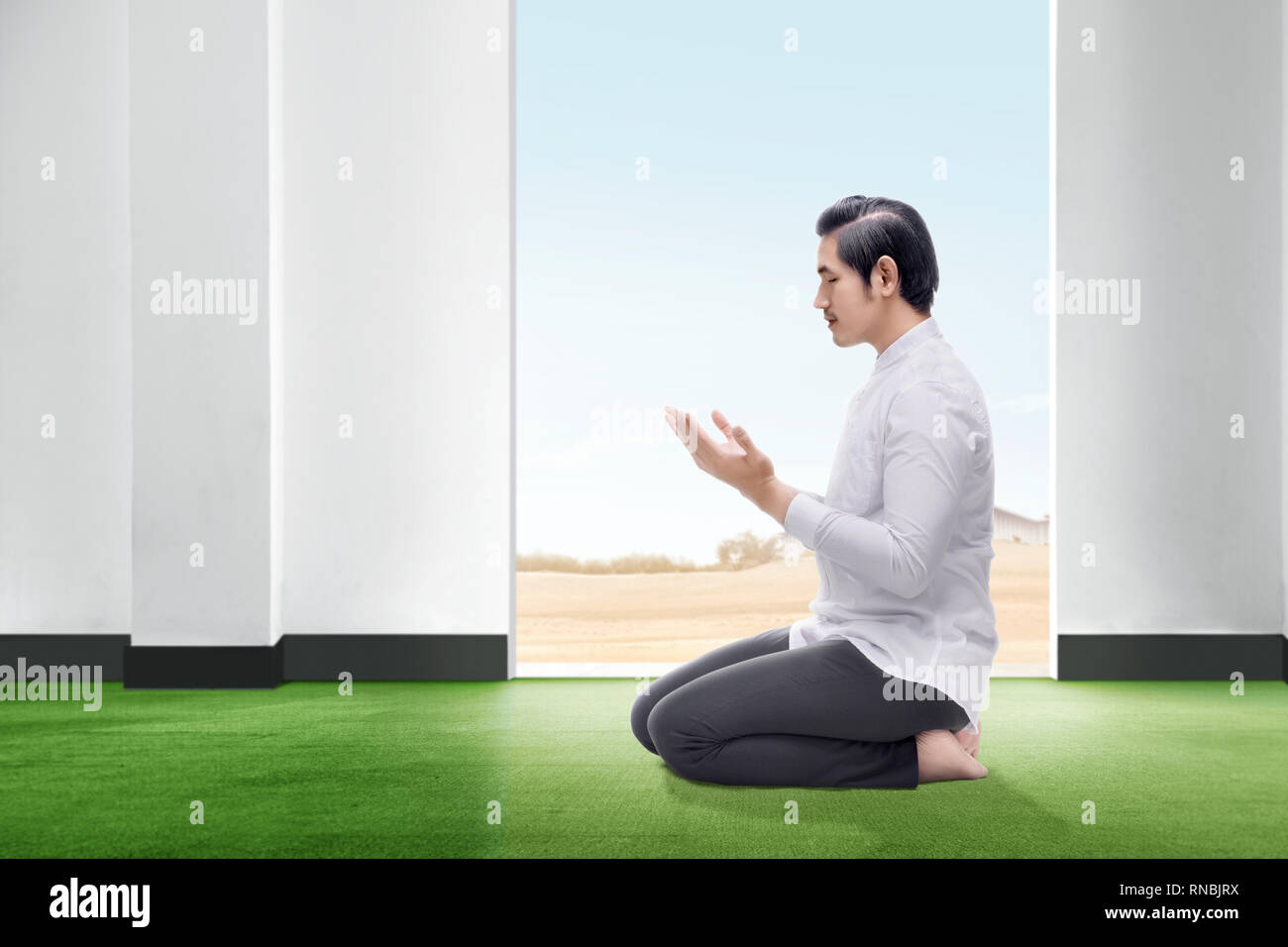 Handsome asian man sitting in praying position close his eyes and raise ...