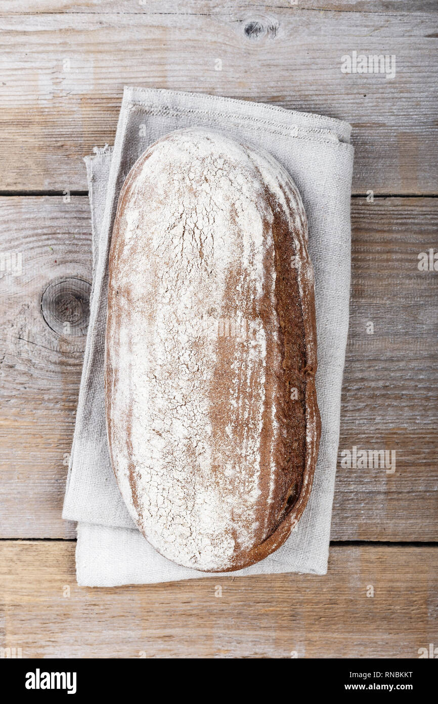 whole loaf of homemade black bread closeup on a wooden background ...