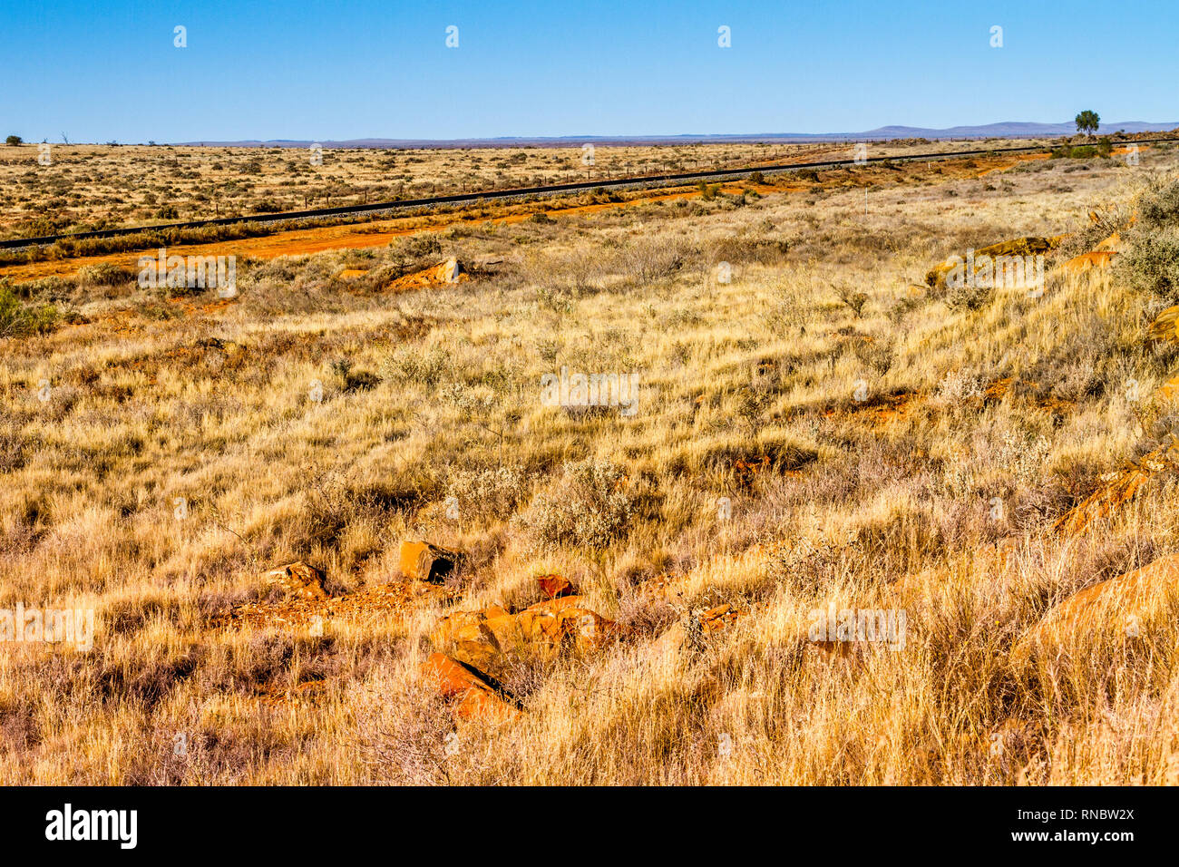 Outback South Australia grasses and railway line hillside and blue sky ...