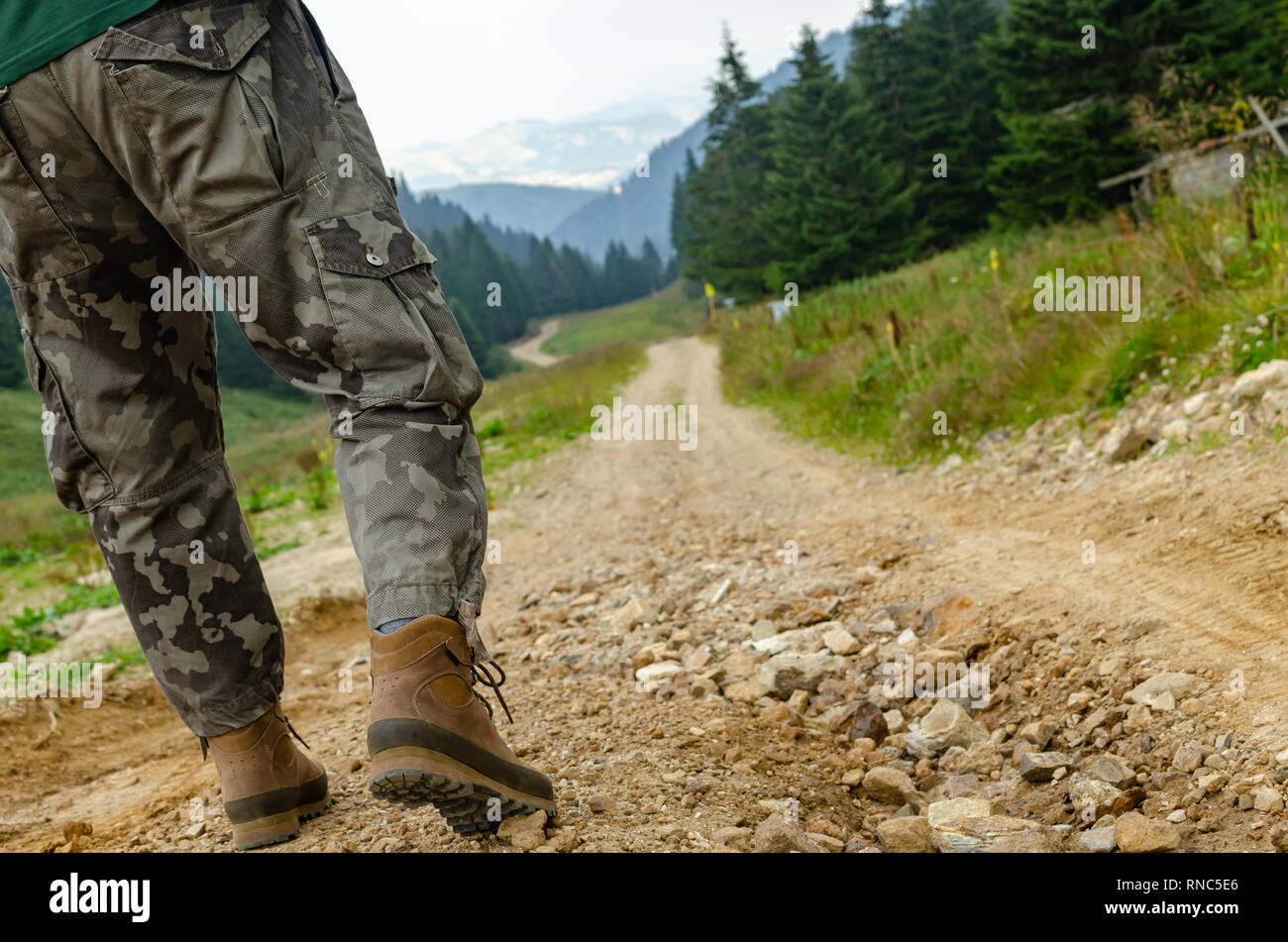 Hiker's legs while walking on a path leading through hills Stock Photo ...