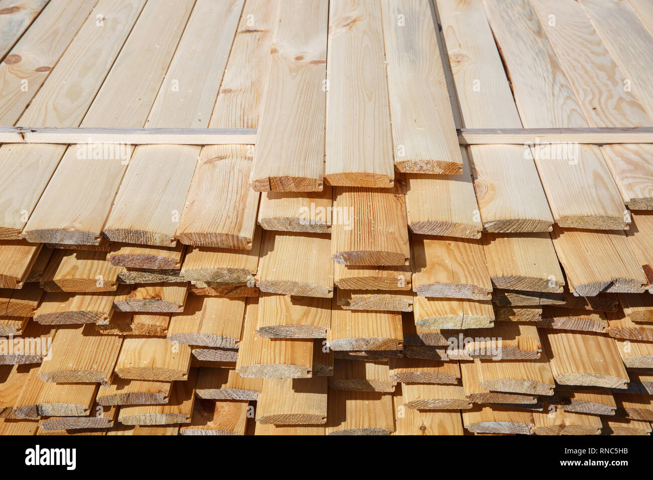 Pile of raw wood planks. Building process, construction site, carpentry ...