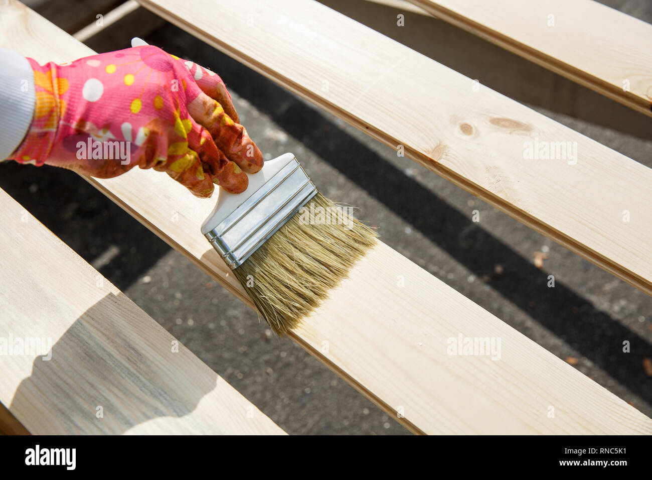 Painter holding a paintbrush over wooden surface, protecting wood for ...
