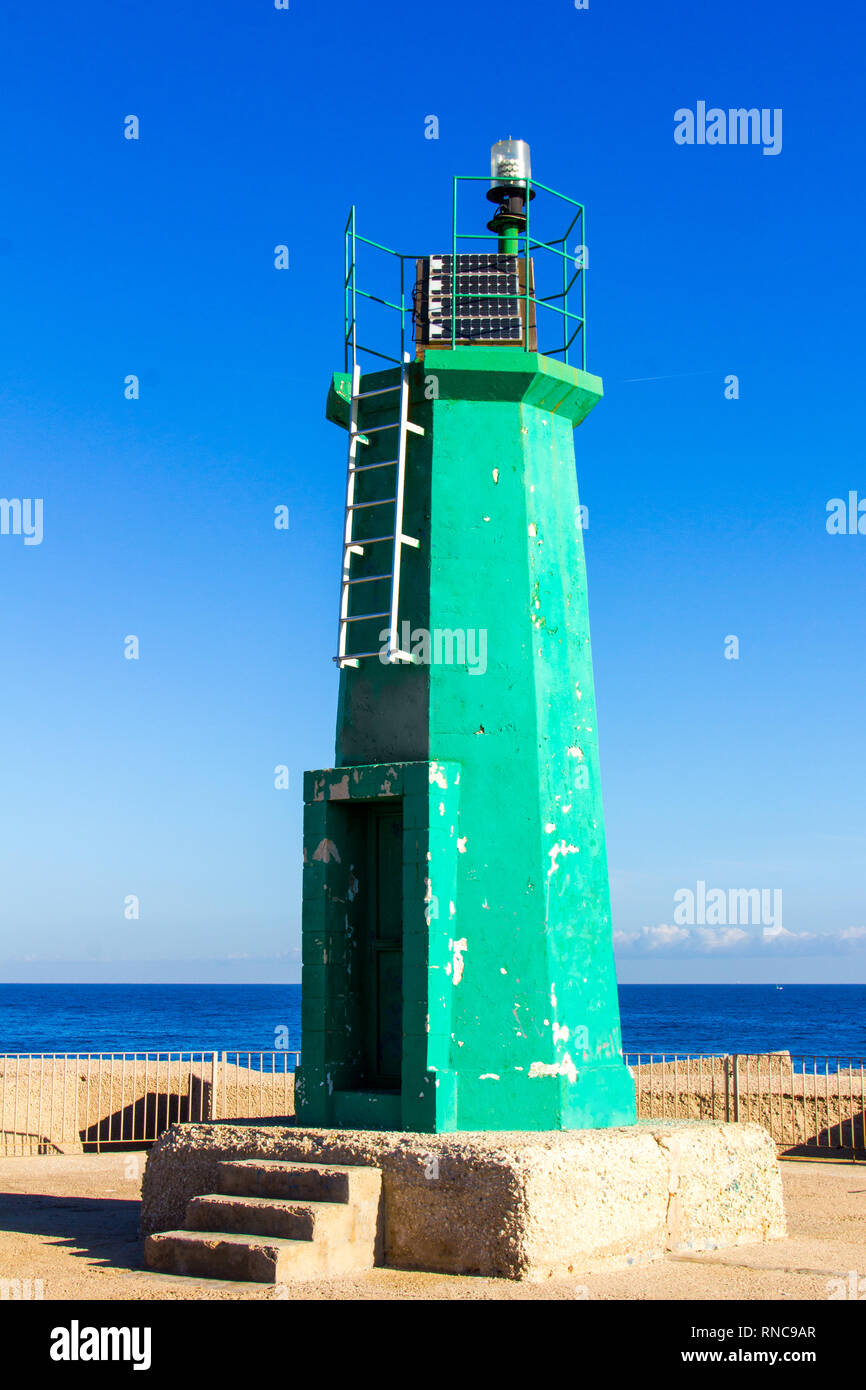 A green lighthouse in Denia, Spain. The blue sky is in the background ...