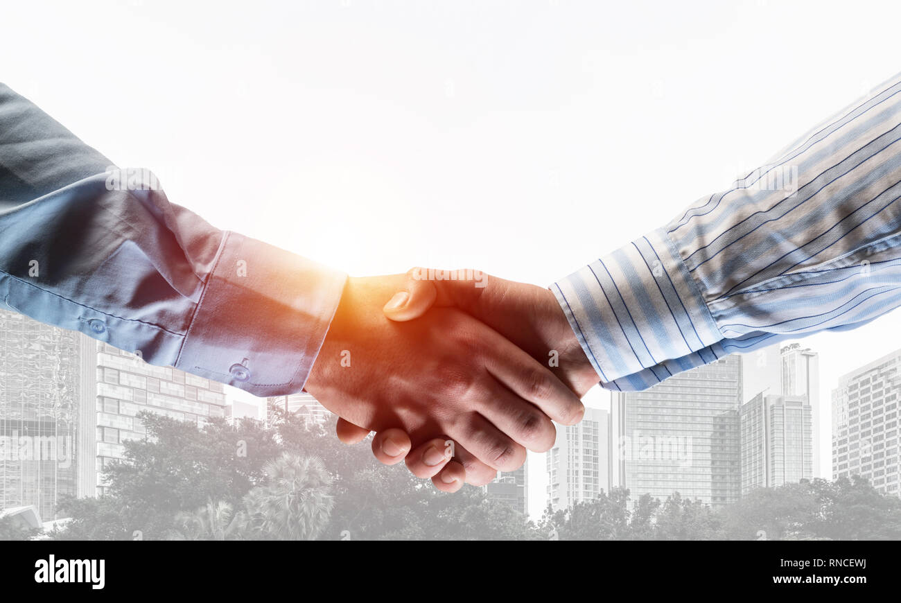 Business handshake as idea for unity and cooperation or greeting. Mixed ...