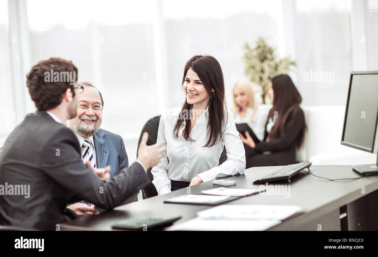 boss and members of the business team sitting at workplace on ...