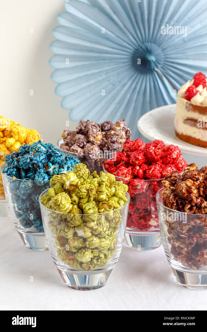 Party table with colorful popcorn in glasses Stock Photo - Alamy