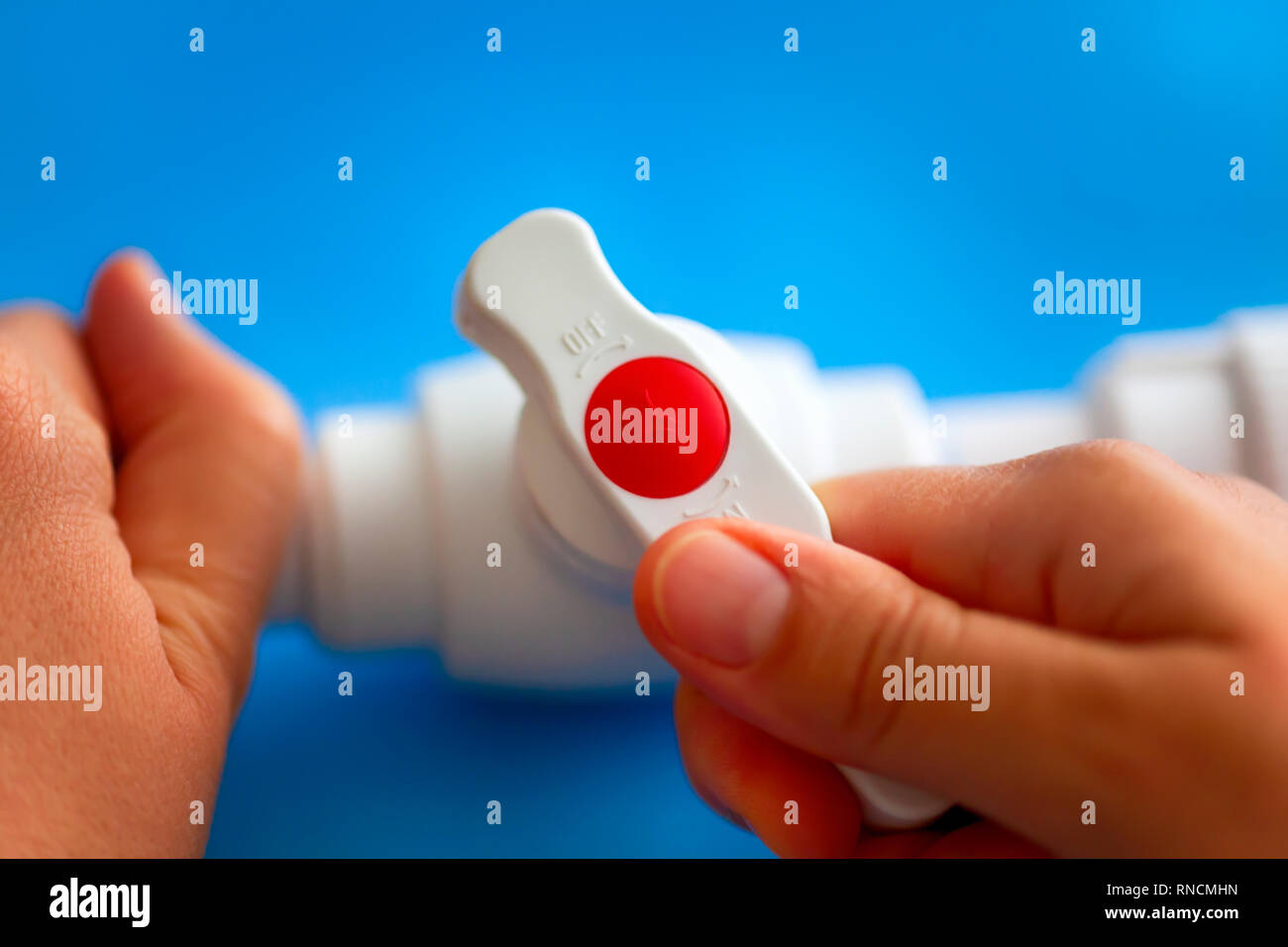 Woman hands turning on switch on pipe. Blue background. Close-up Stock ...