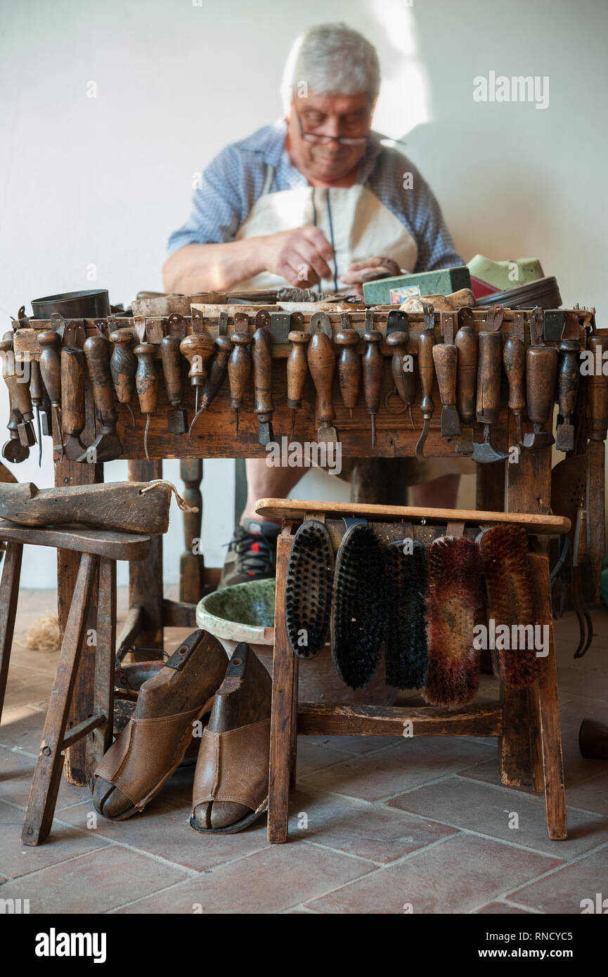 The shoemaker at his work bench. Various tools and instrument are ...
