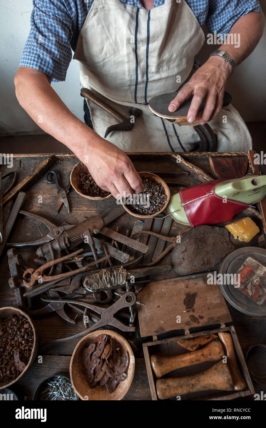 The shoemaker at his work bench. Various tools and instrument are ...