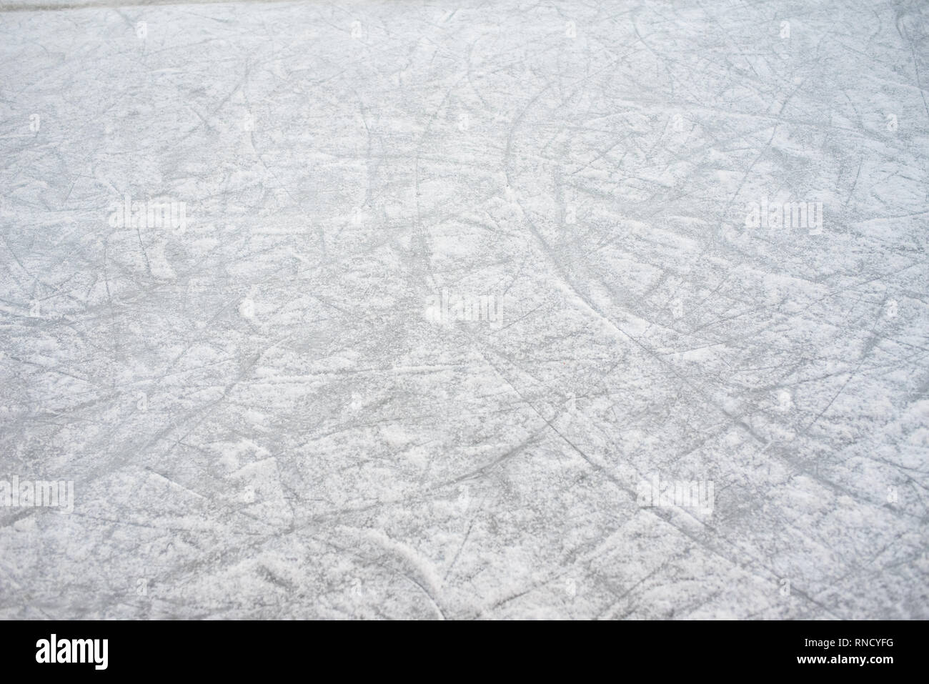 Floor background of a frozen ice rink with skate marks, with white snow ...