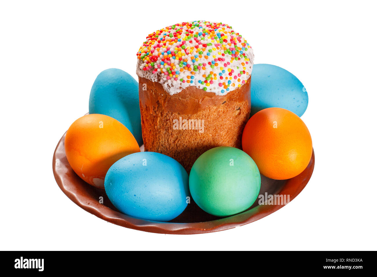 Easter cake and painted eggs on a brown plate isolated on the white ...