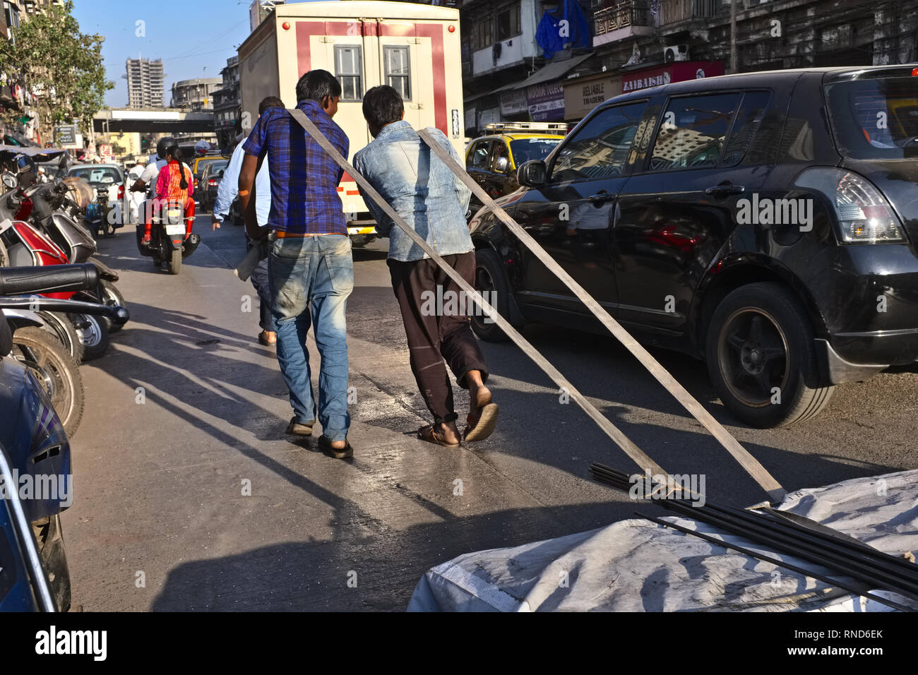 Load carriers pulling a cart with heavy metal sheets on a delivery run ...