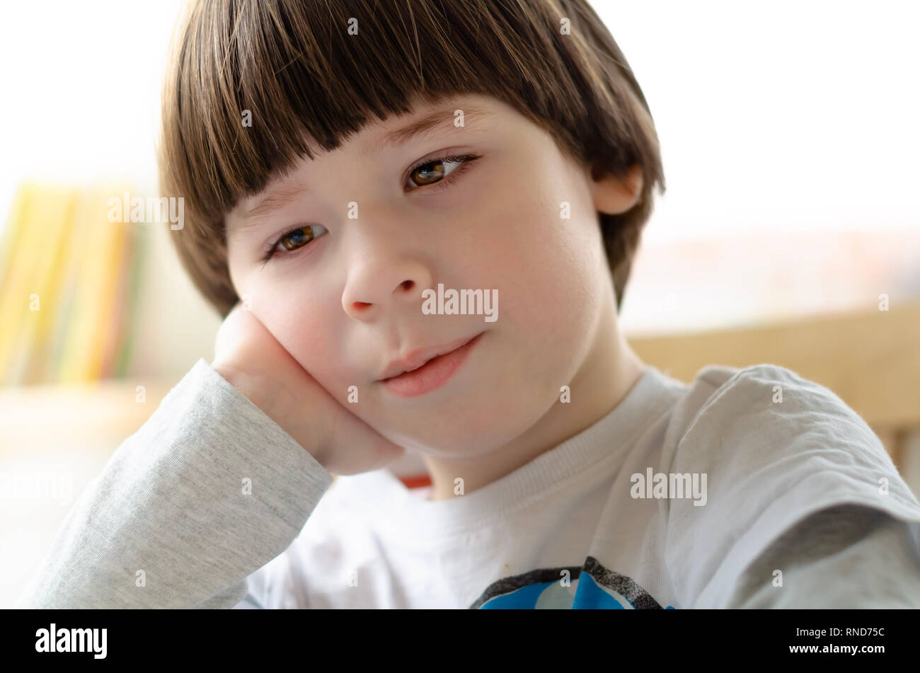 Boy is sitting and resting his head on his arm Stock Photo - Alamy