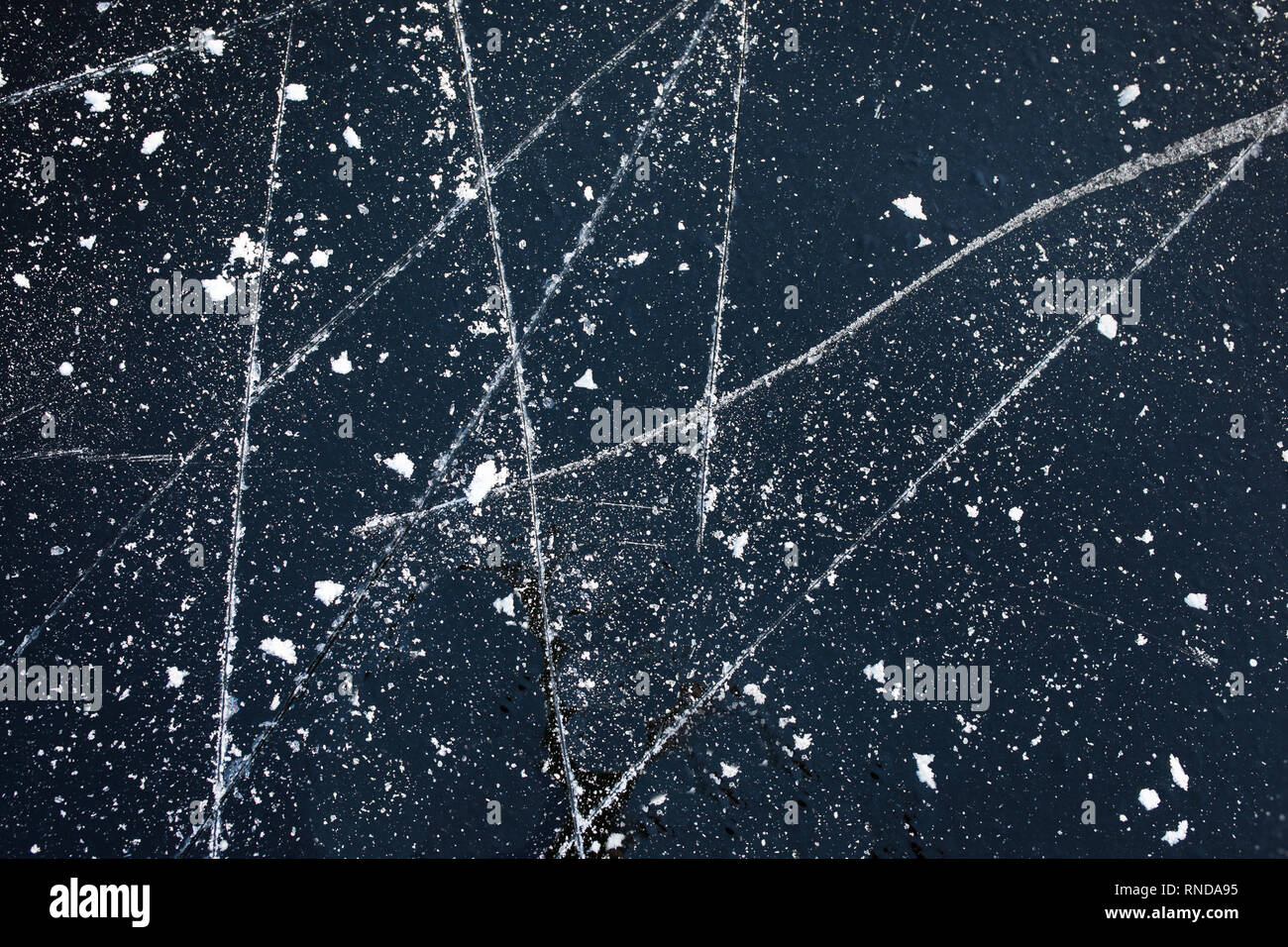 Surface of outdoor ice with snow, replete with skate marks. close-up ...