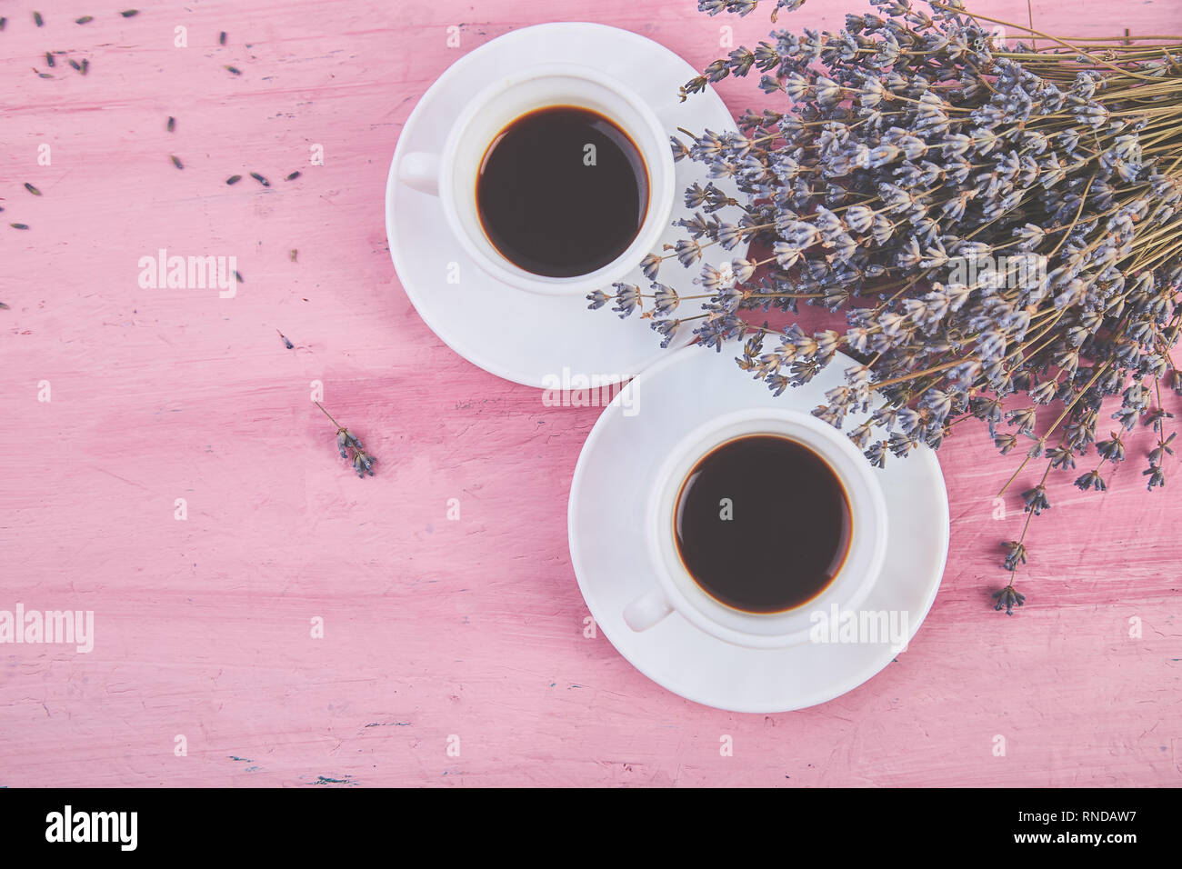Two cups of coffee with bouquet of flowers lavender on pink table. Good ...