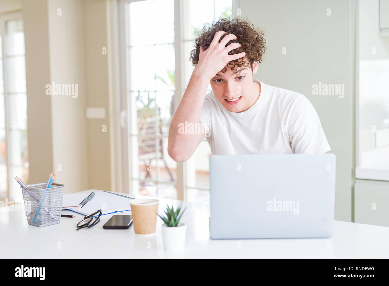 Young student man working and studying using computer laptop stressed ...
