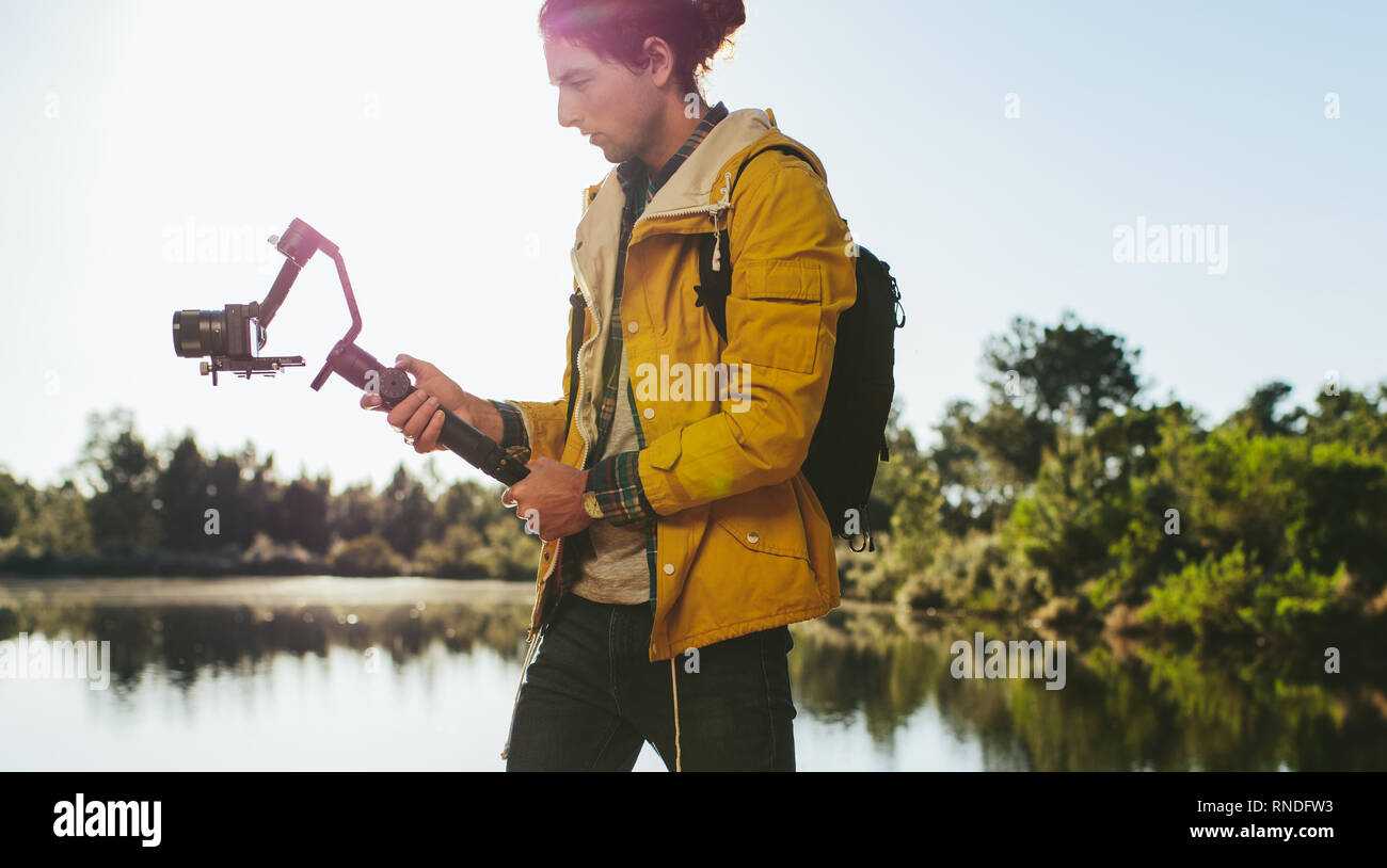 Content creator shooting a video using a mirrorless camera mounted on a ...