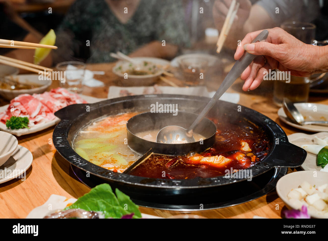 Woman taking food from pot Stock Photo - Alamy