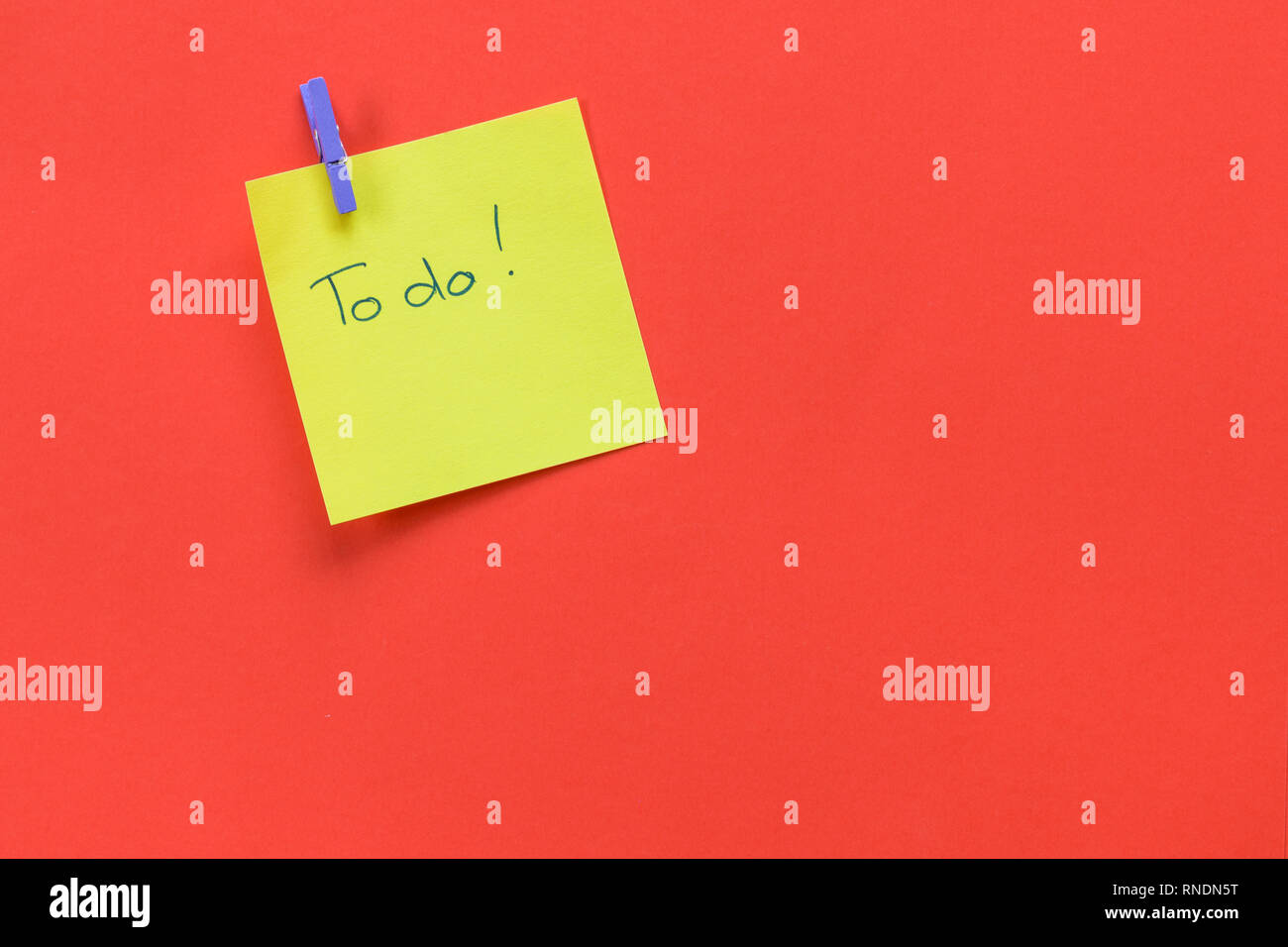 Yellow sticky note with text 'To do' isolated on a red background and ...