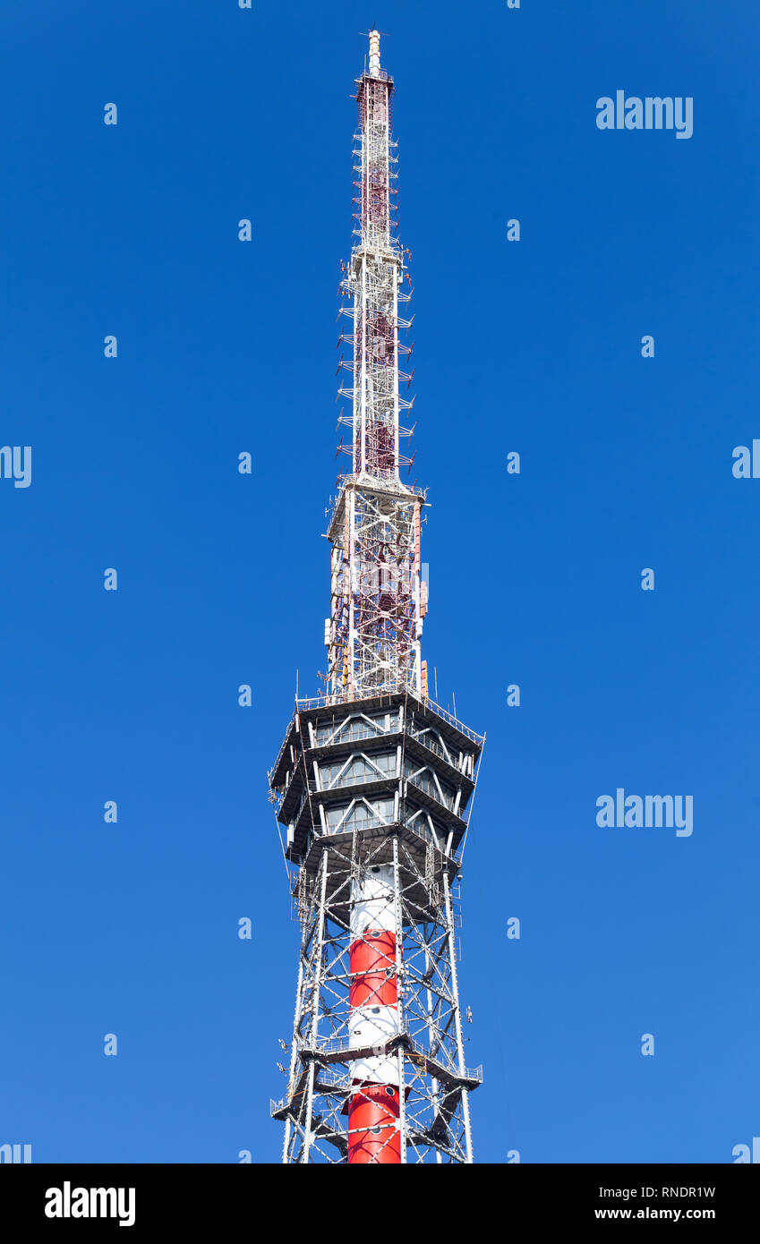 Upper part of television broadcasting tower over blue sky. St ...