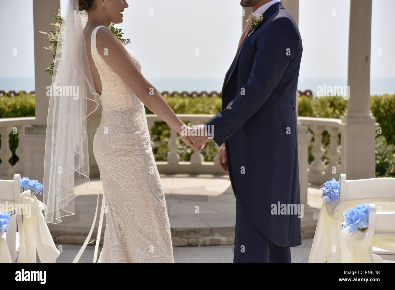 Beautiful white couple get married by the sea on a glorious Summer day ...