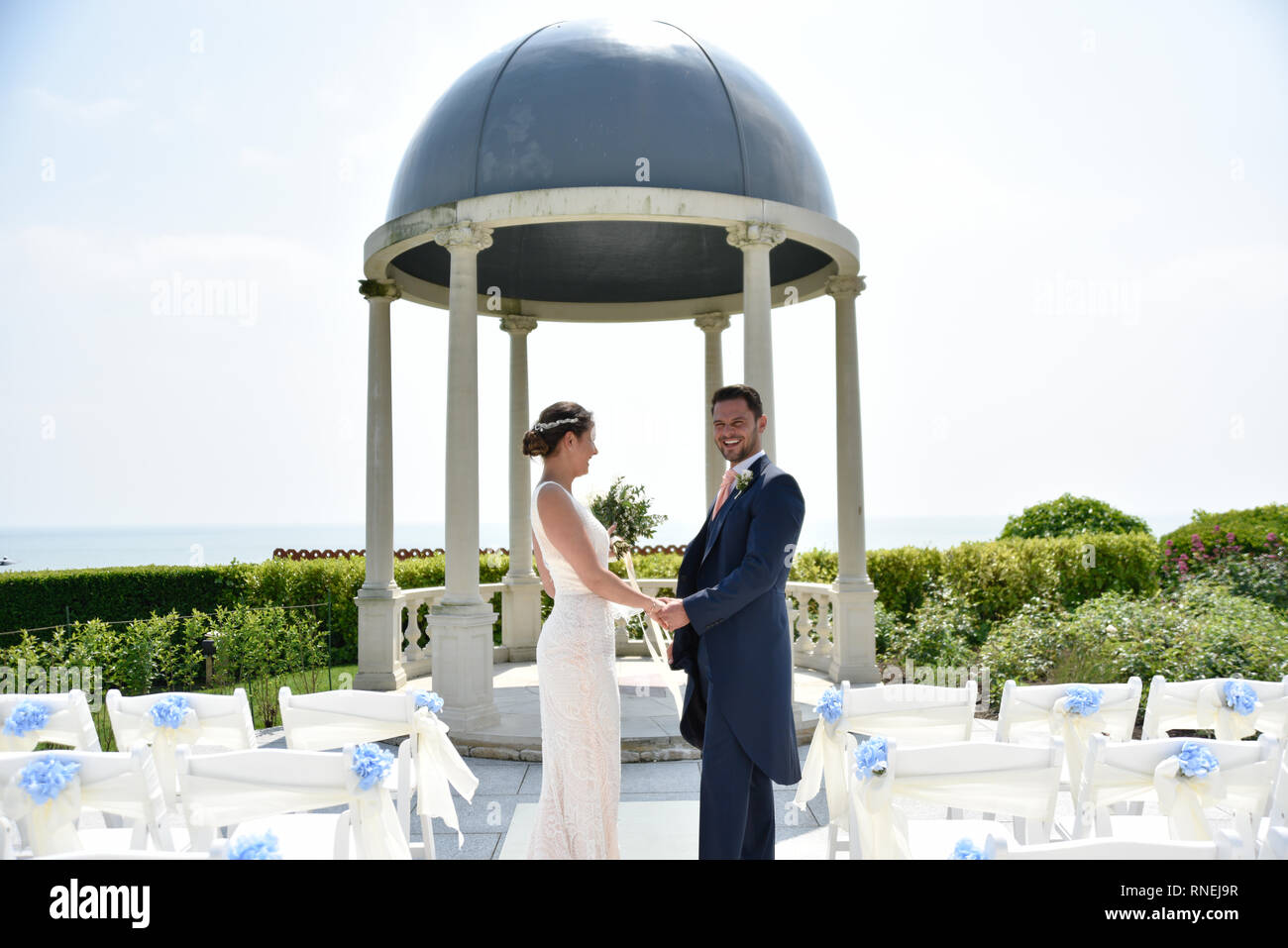 Beautiful white couple get married by the sea on a glorious Summer day ...
