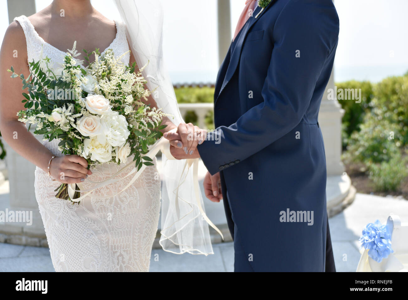 Beautiful white couple get married by the sea on a glorious Summer day ...