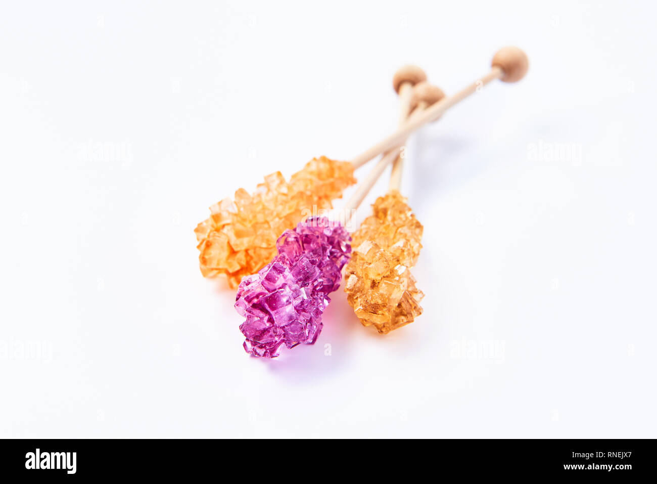 Rock candy or orange and purple sugar candy isolated on white ...