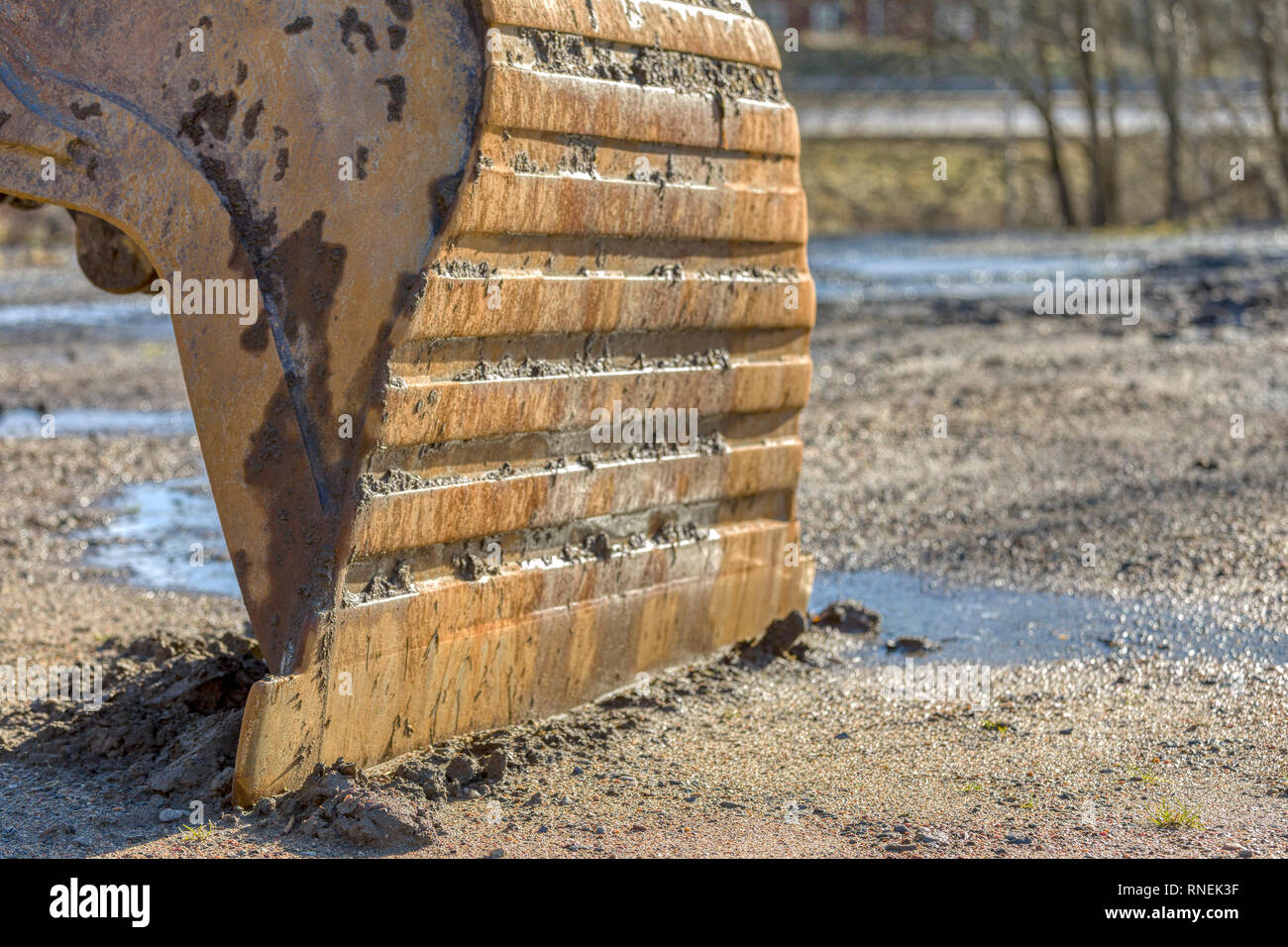 Close up view of attached excavator bucket and bucket teeth resting on ...