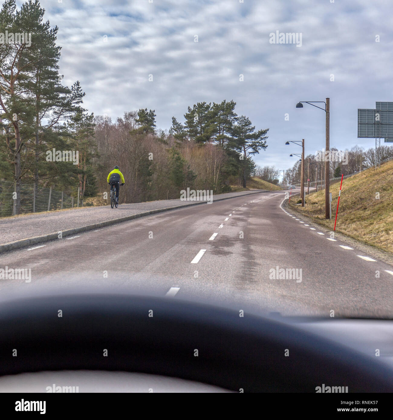 Two lane road or highway aka single carriageway with cyclist on bicycle ...