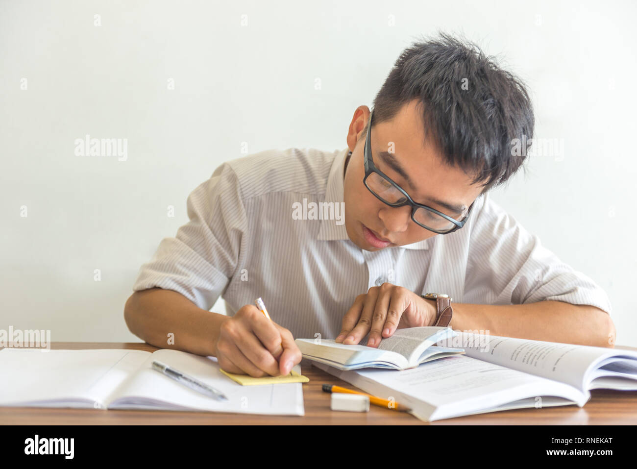Asian student doing homework at the library Stock Photo - Alamy