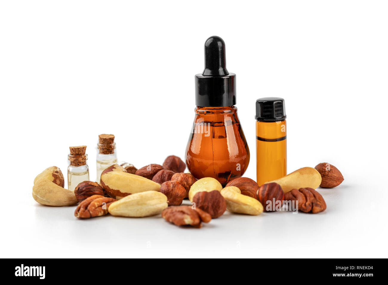 nut oil bottles with nuts mix isolated on white background Stock Photo ...