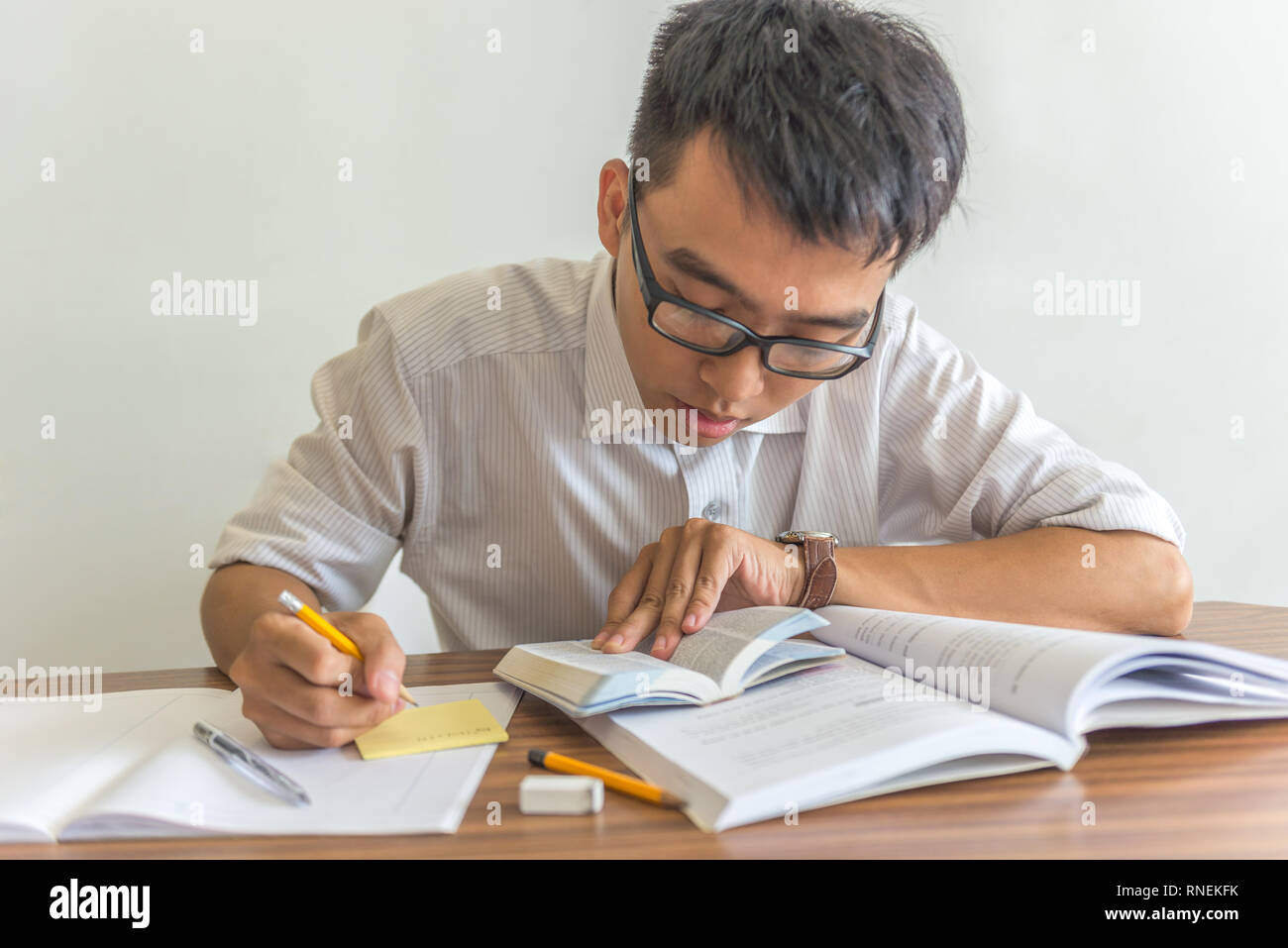 Young Asian man studying in the library Stock Photo - Alamy