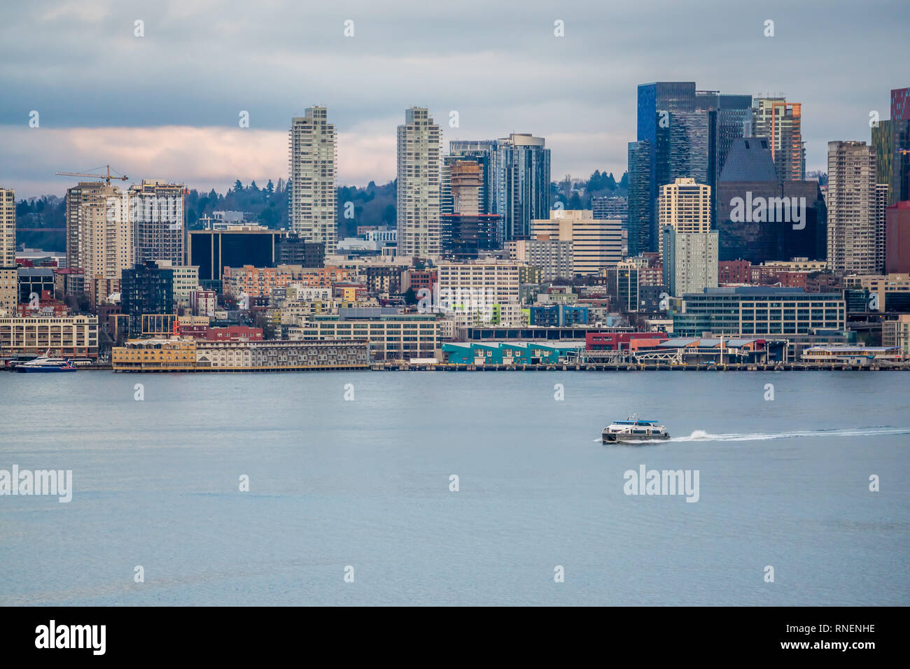 A boat cruises across Elliott Bay in front of the Seattle skyline Stock ...
