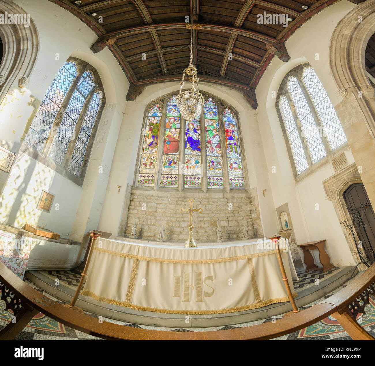 Altar and stained glass window in the church of St John Baptist at the ...