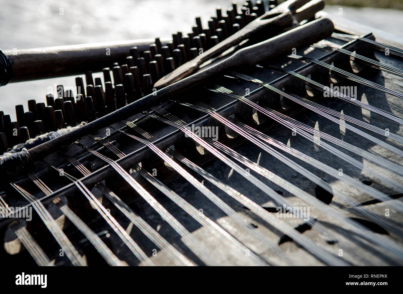 Old wooden stringed musical instrument stands under the open sky ...