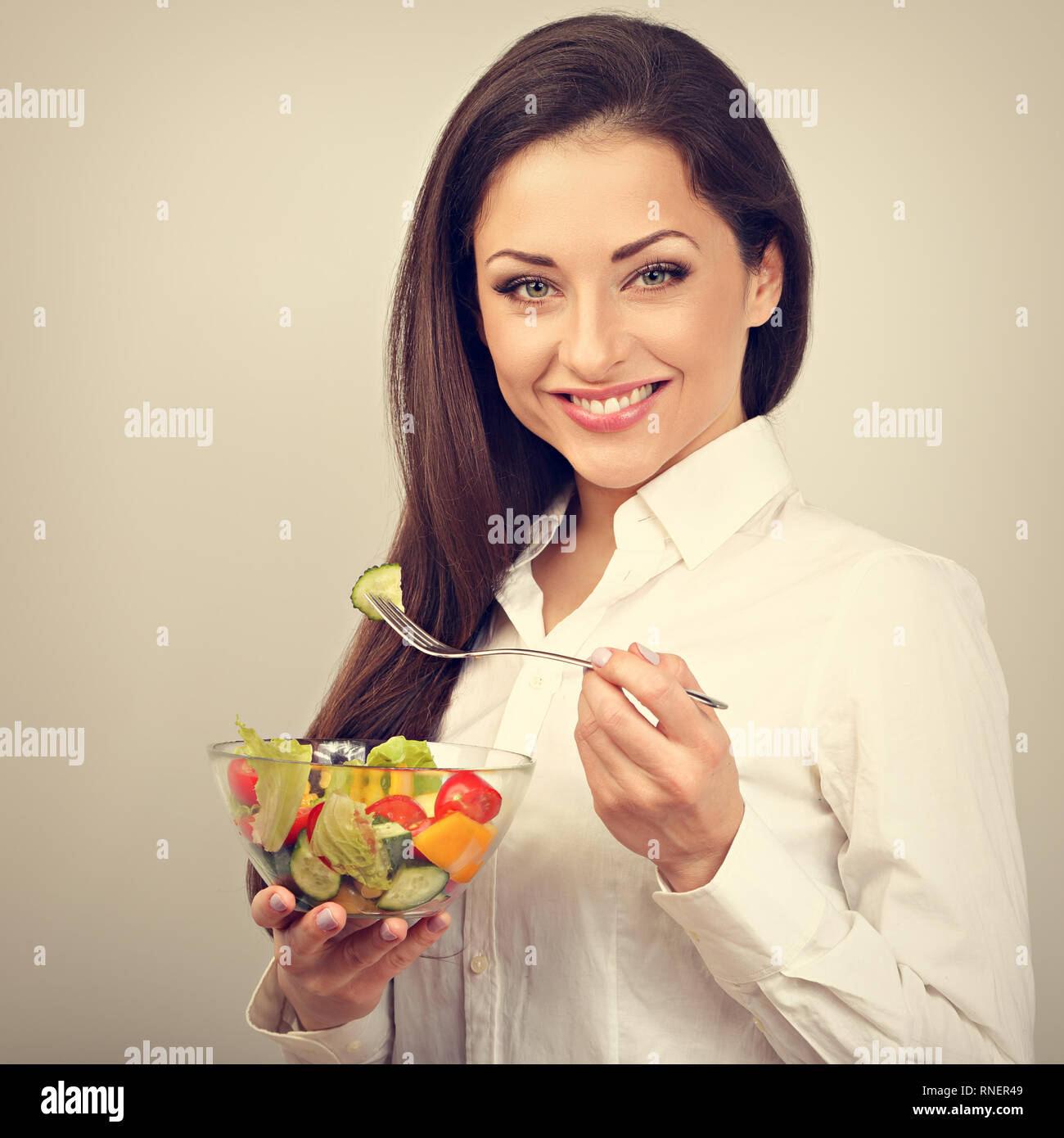 Beautiful smiling business woman eating healthy organic vegatable salad ...
