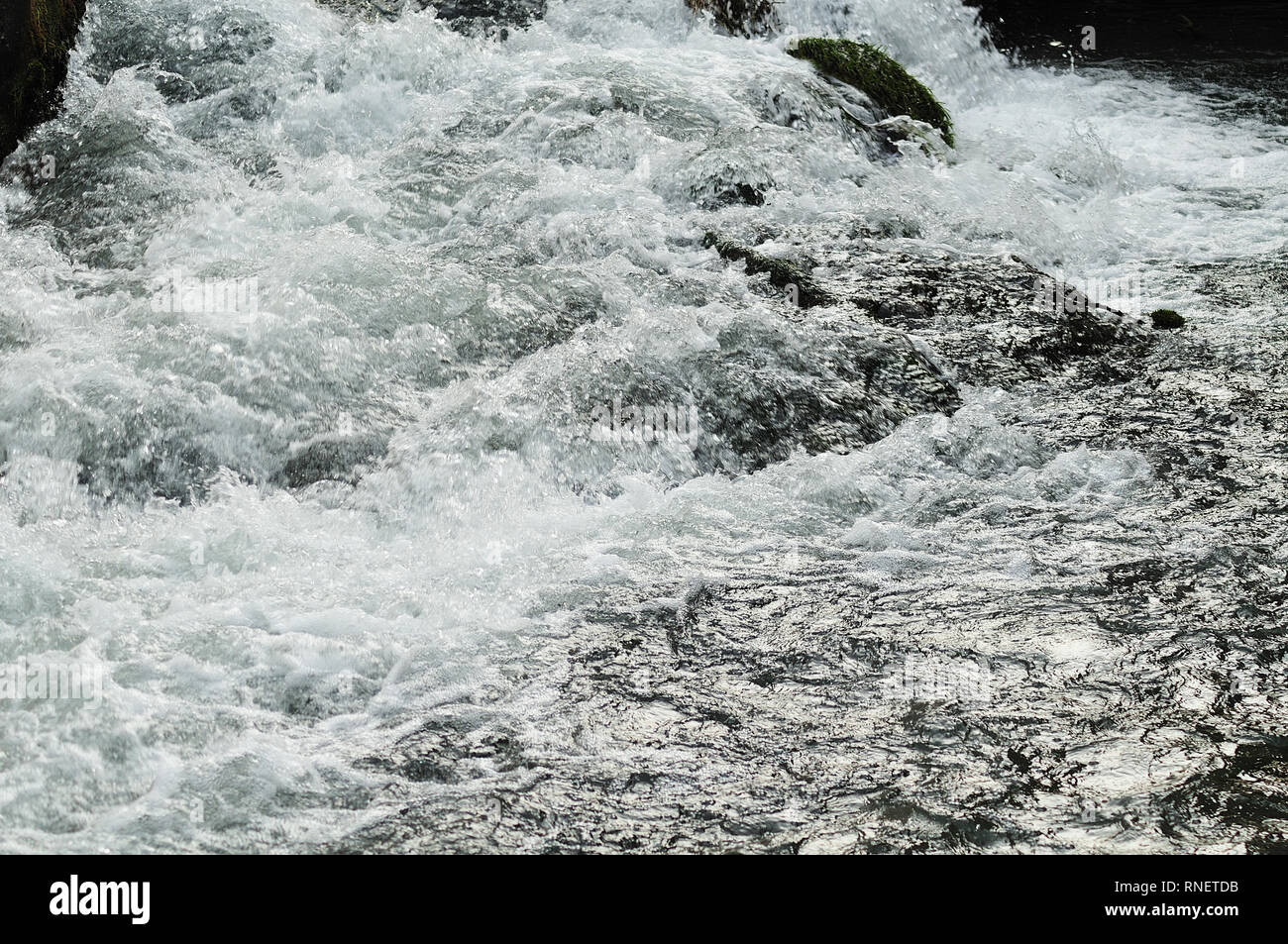 rapids with turbulent water splashing over rocks in a river Stock Photo ...
