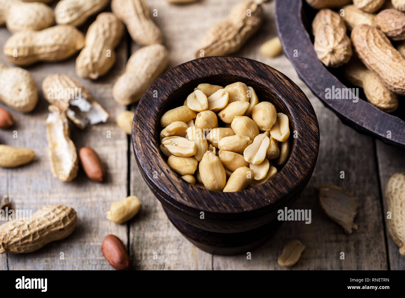 Peanuts in small dark wooden bowl on natural rustic desk Stock Photo ...
