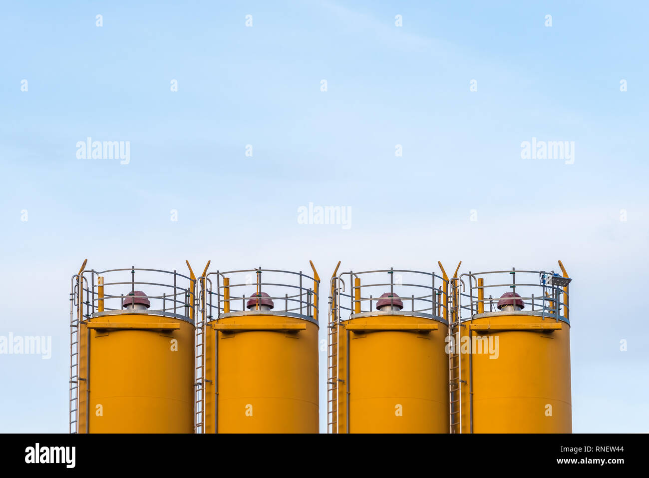 Four silos in front of blue sky Stock Photo - Alamy