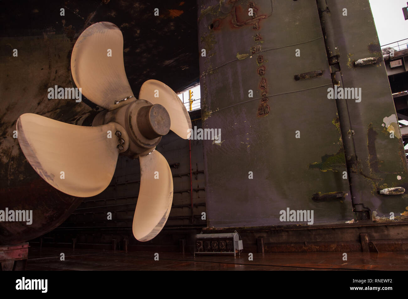 View of ship propeller and rudder in a dry dock background ...