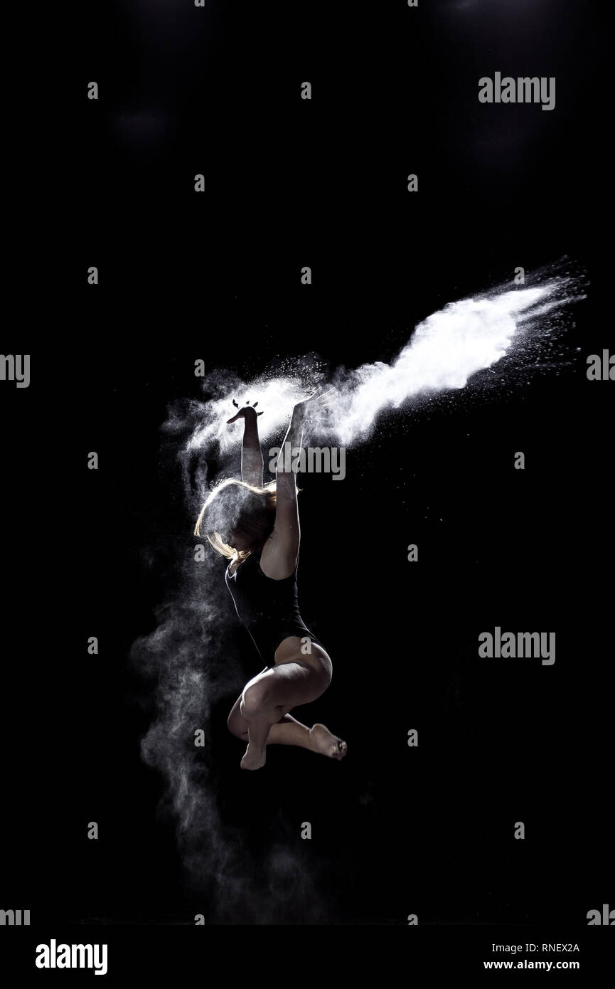 Girl dancing with a flour on black background Stock Photo - Alamy
