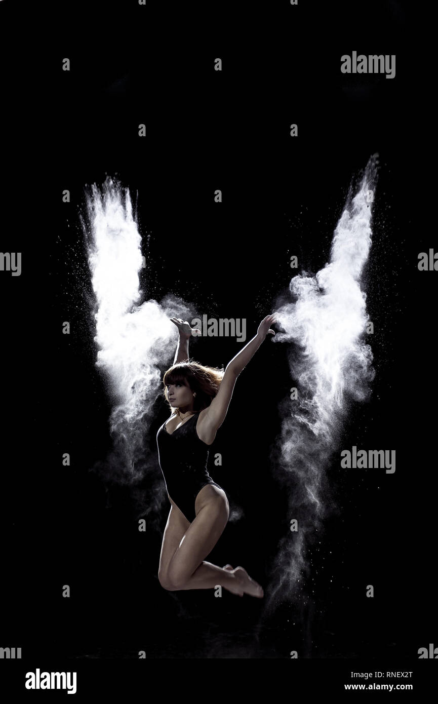 Girl dancing with a flour on black background Stock Photo - Alamy