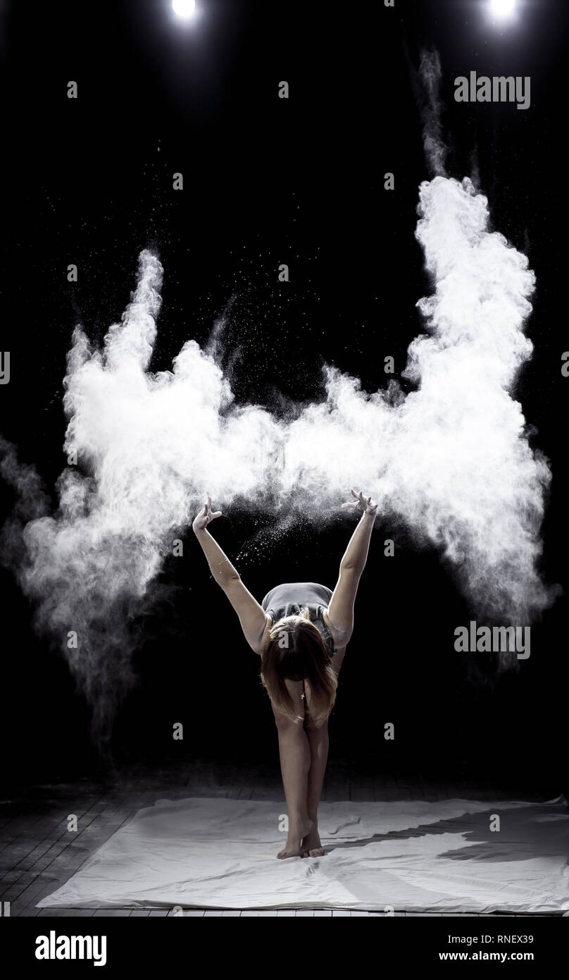 Girl dancing with a flour on black background Stock Photo - Alamy