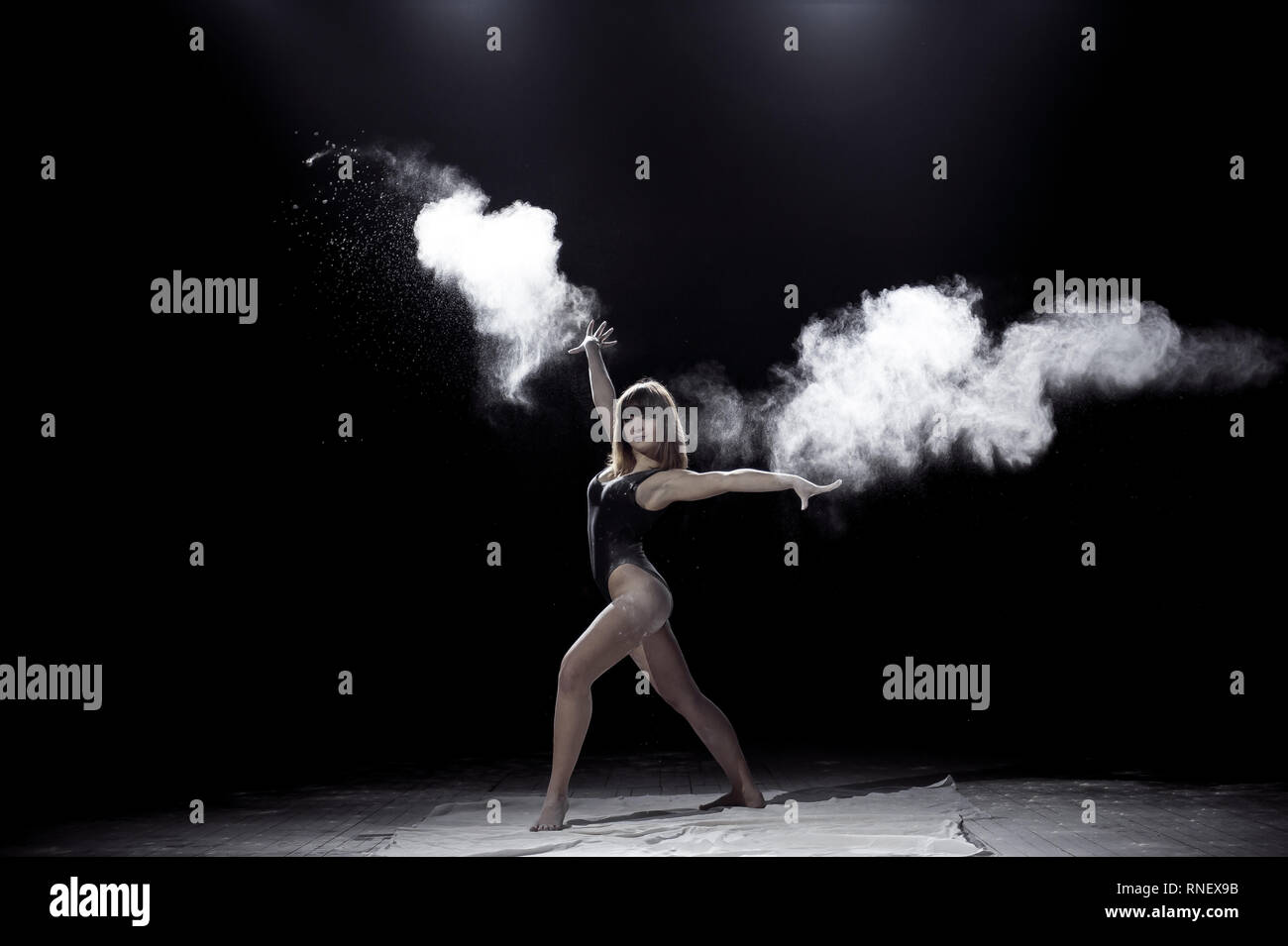 Girl dancing with a flour on black background Stock Photo - Alamy