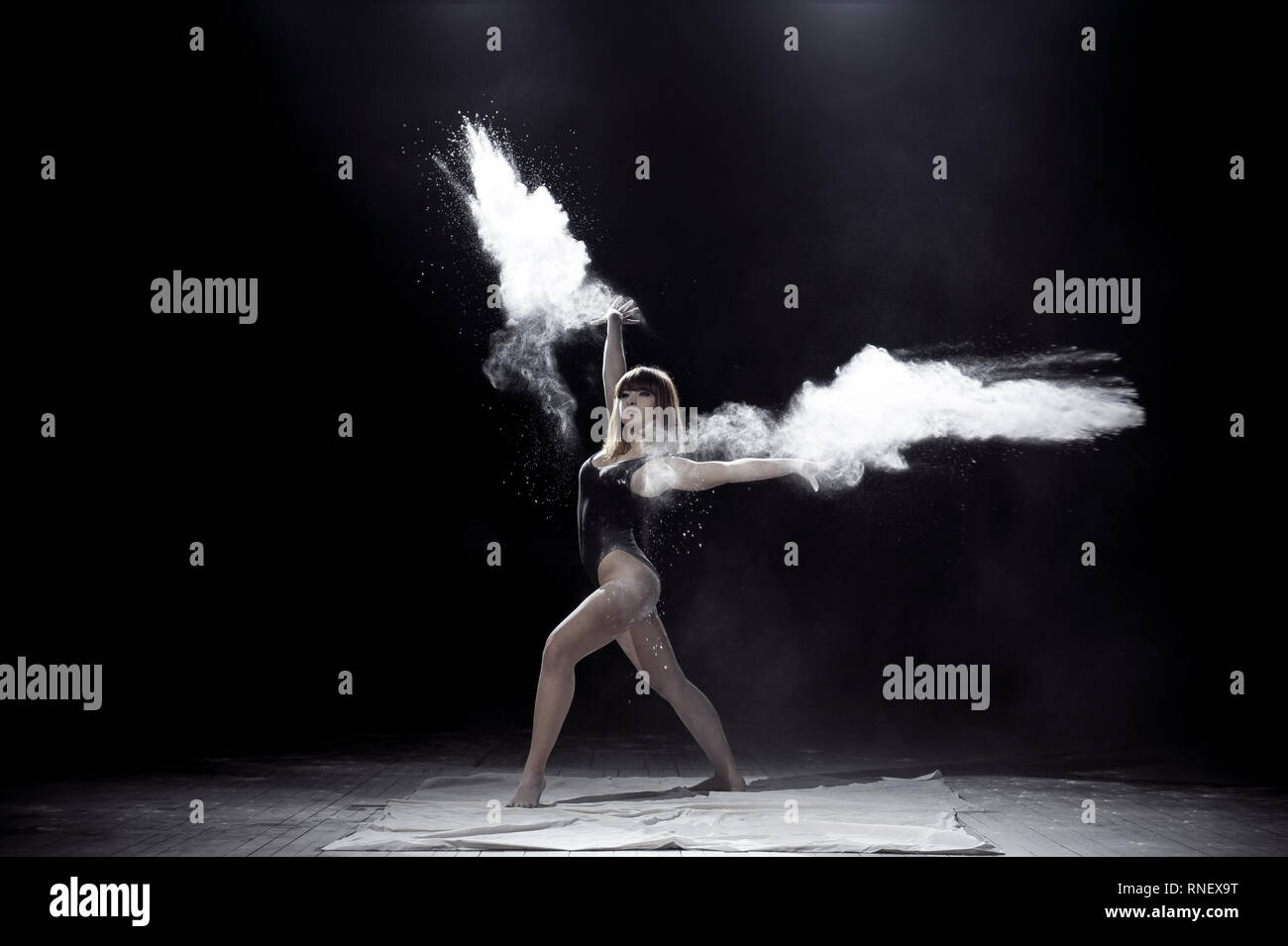 Girl dancing with a flour on black background Stock Photo - Alamy