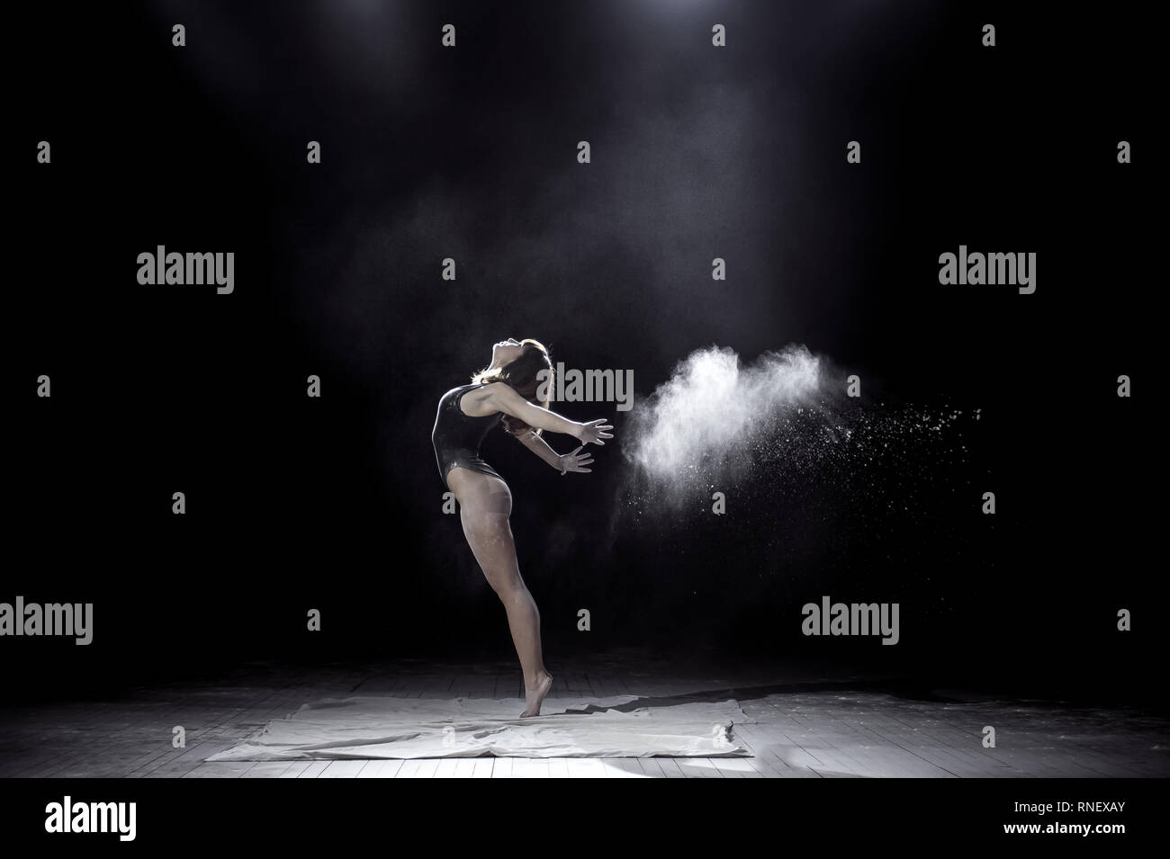Girl dancing with a flour on black background Stock Photo - Alamy