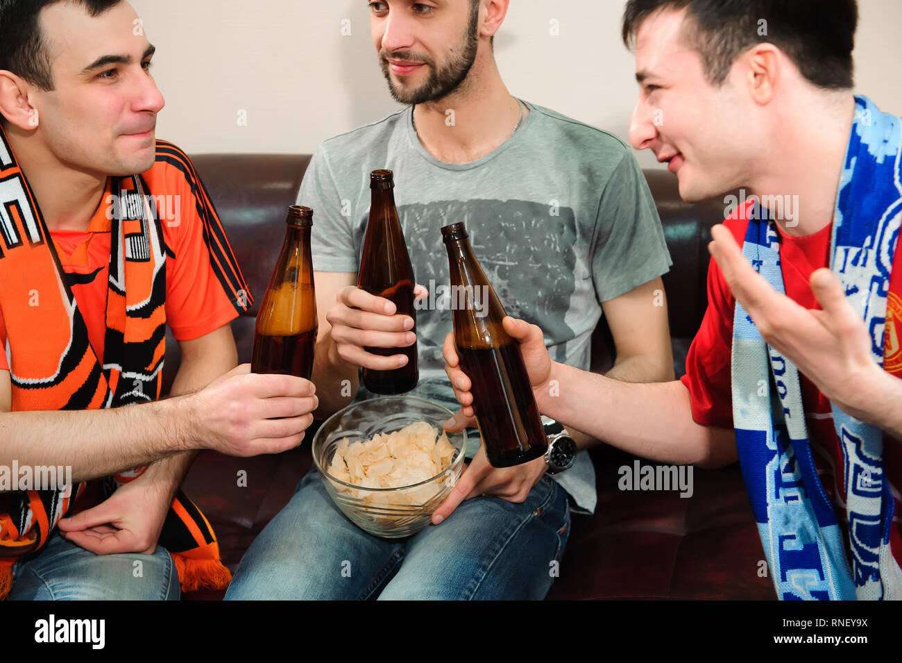 Friends cheering and drinking alcohol while watching soccer Stock Photo ...